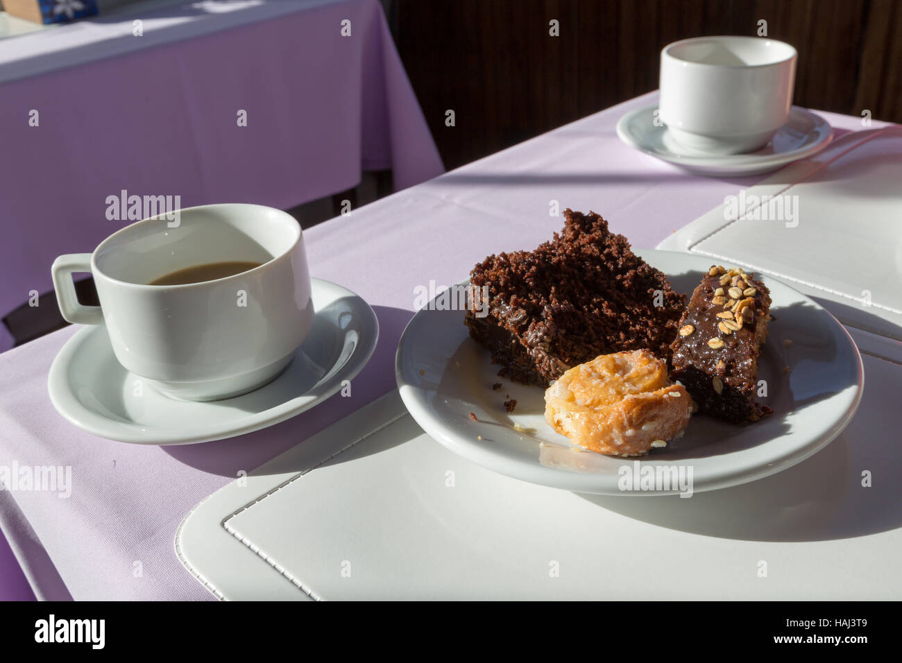 Cakes and two coffee cups on table Stock Photo - Alamy