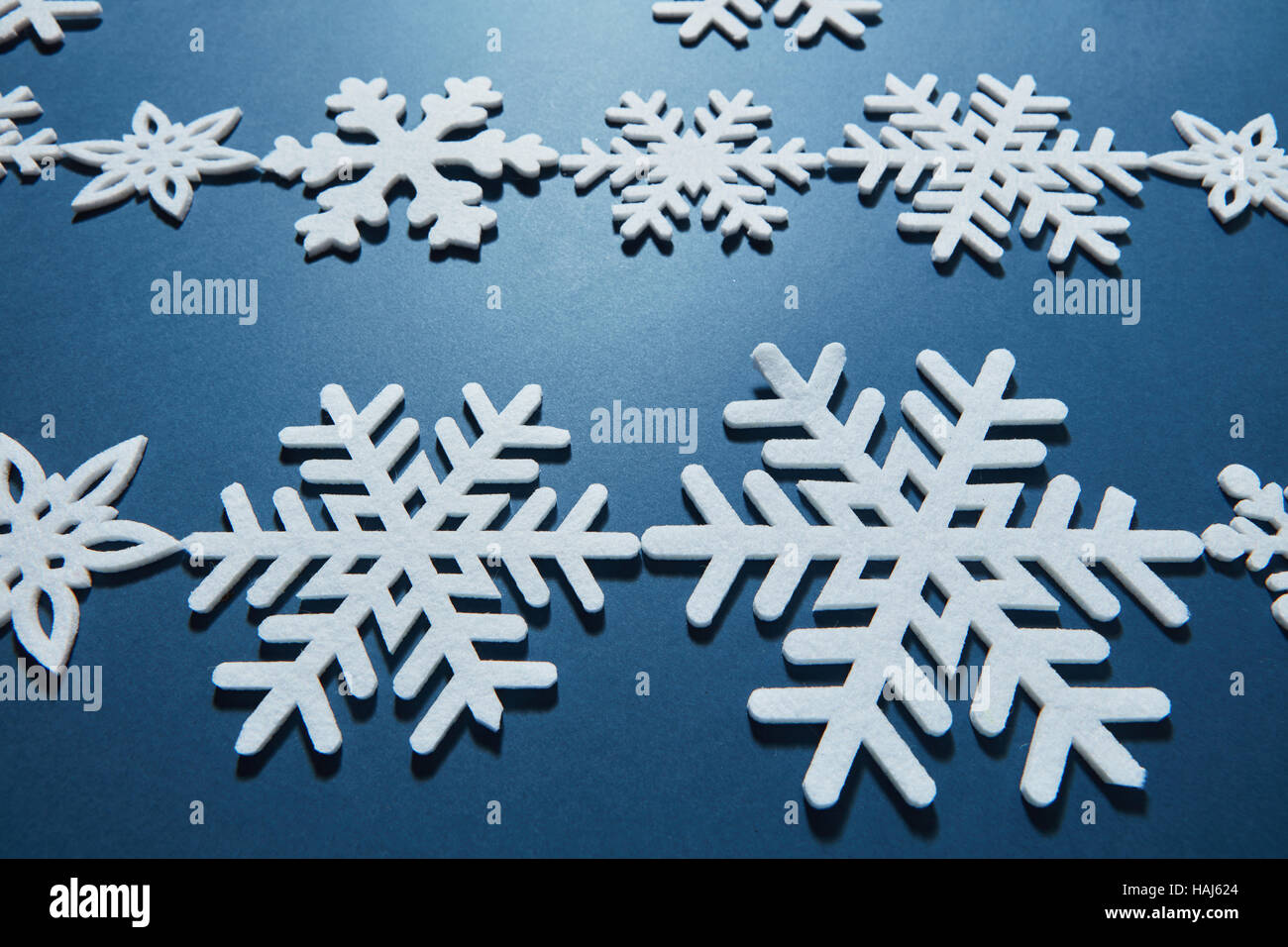 Snowflakes of different sizes in a row on a blue background Stock Photo ...
