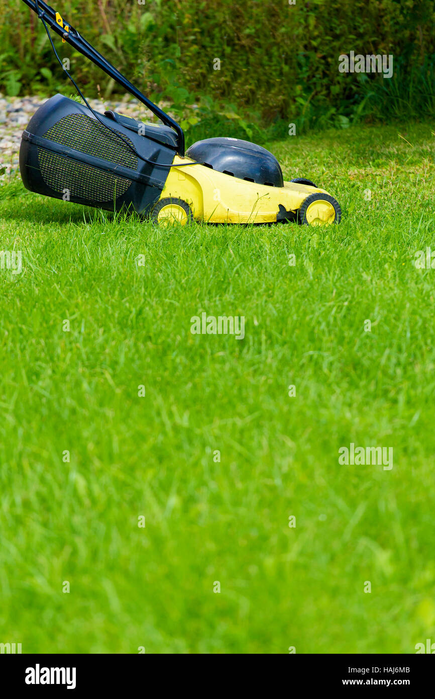 Young man gardener using lawn mower Stock Photo - Alamy