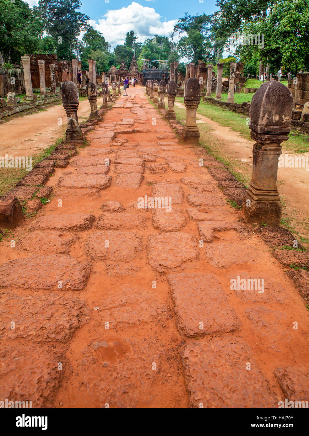 A heavily worn red sandstone road leads visitors to the main temples at ...
