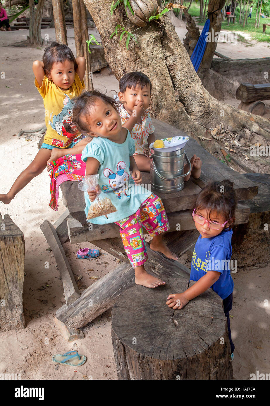 Four happy Cambodian children share a snack together in Banteay Srei ...