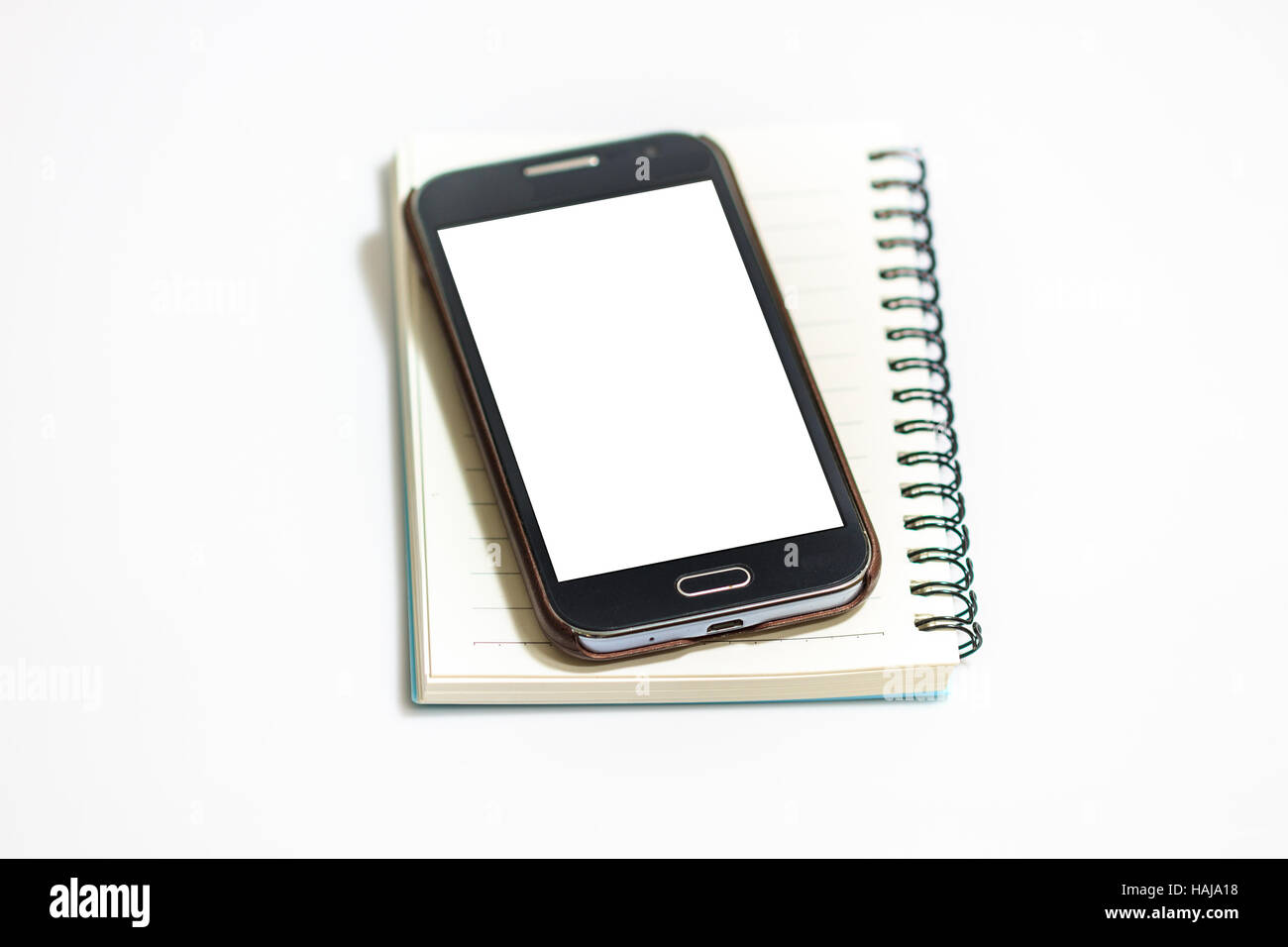Opened notepad with smart phone on white background Stock Photo - Alamy