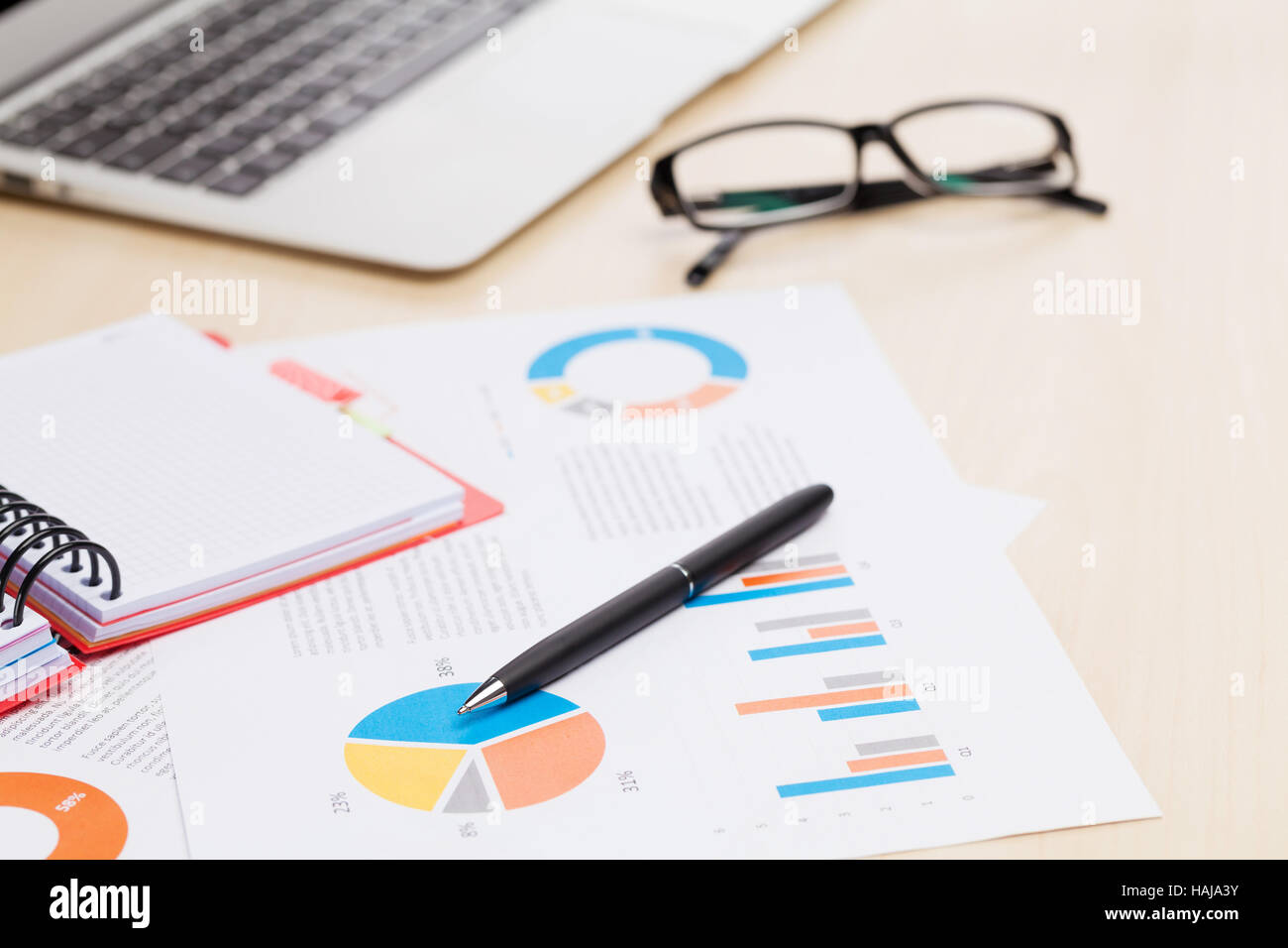 Office workplace with with laptop and reports on wooden desk table ...