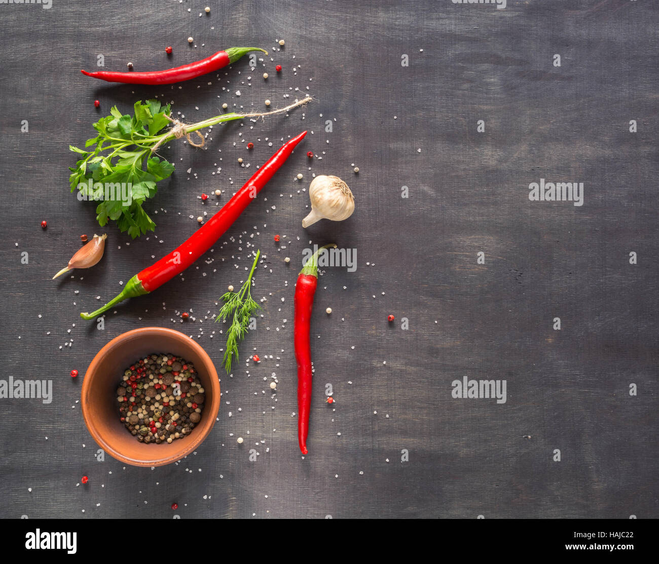 Parsley dill pepper and garlic in a dark wooden table. View from above ...