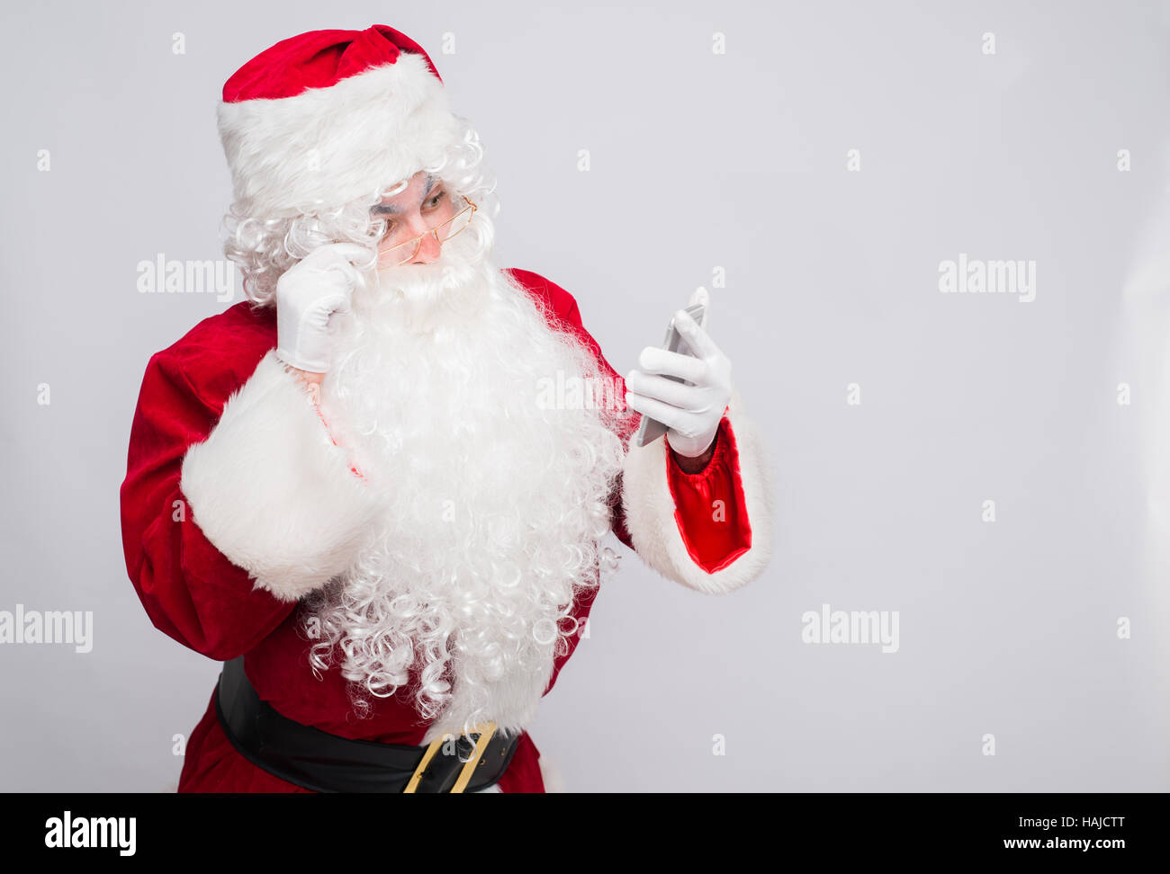 Happy Santa Claus looking on the mobile phone Stock Photo - Alamy