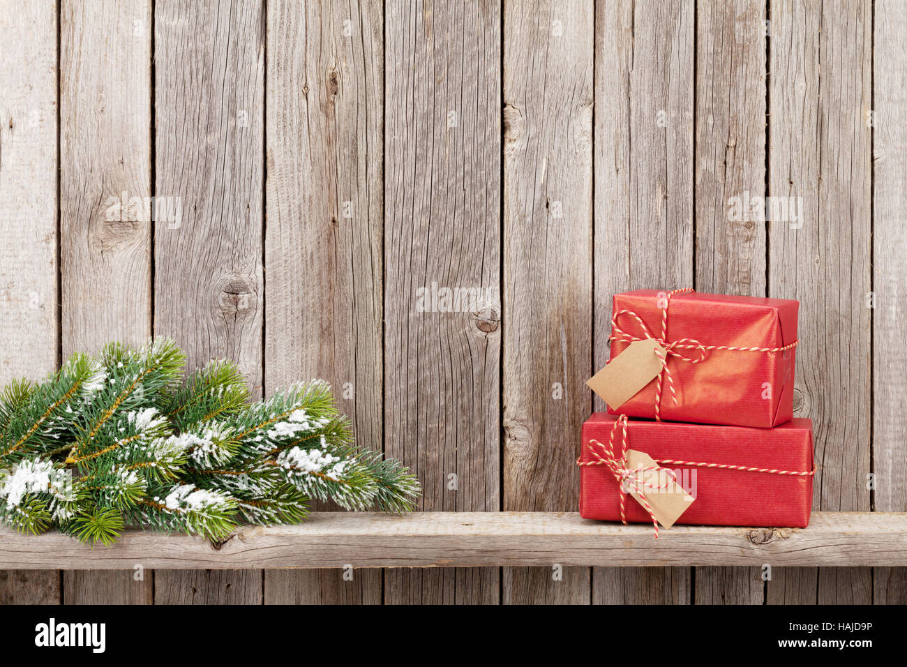 Christmas gift boxes and fir tree toy in front of wooden wall. View ...
