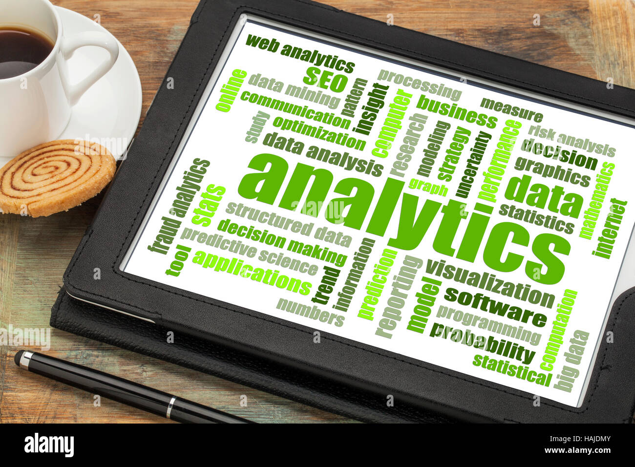 analytics and data analysis word cloud on a digital tablet with a cup ...