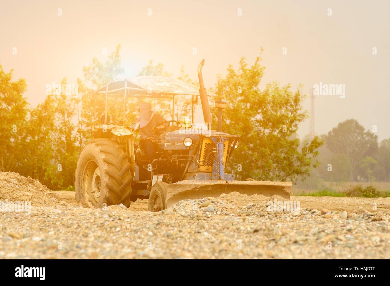 Tractor with worker on duty,constructor site Stock Photo - Alamy