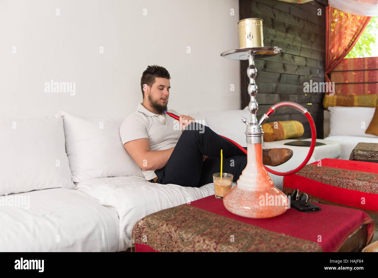 Young Man Smoking Shisha At Arabic Restaurant - Man Exhaling Smoke ...