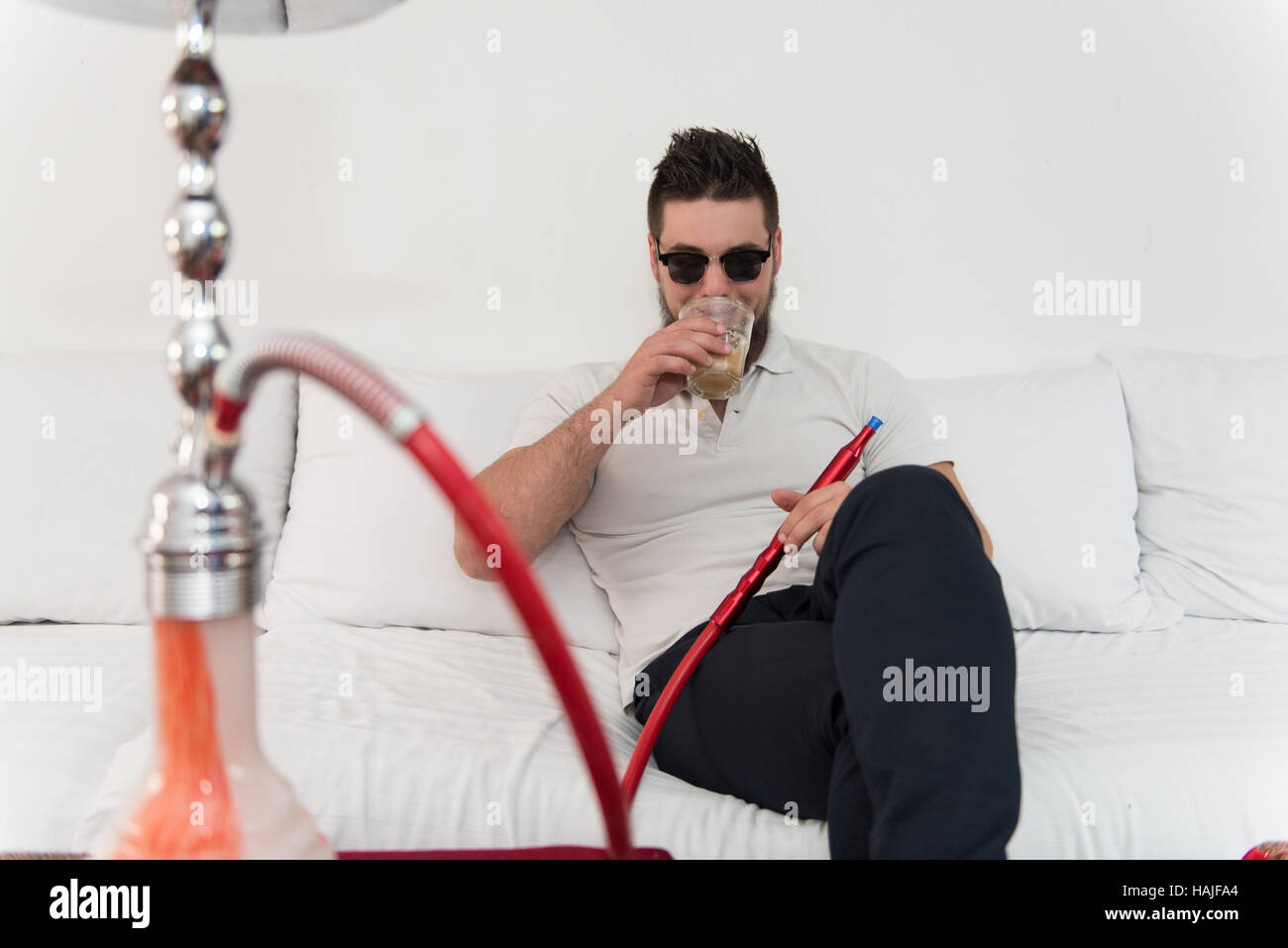 Young Man Smoking Shisha At Arabic Restaurant - Man Exhaling Smoke ...