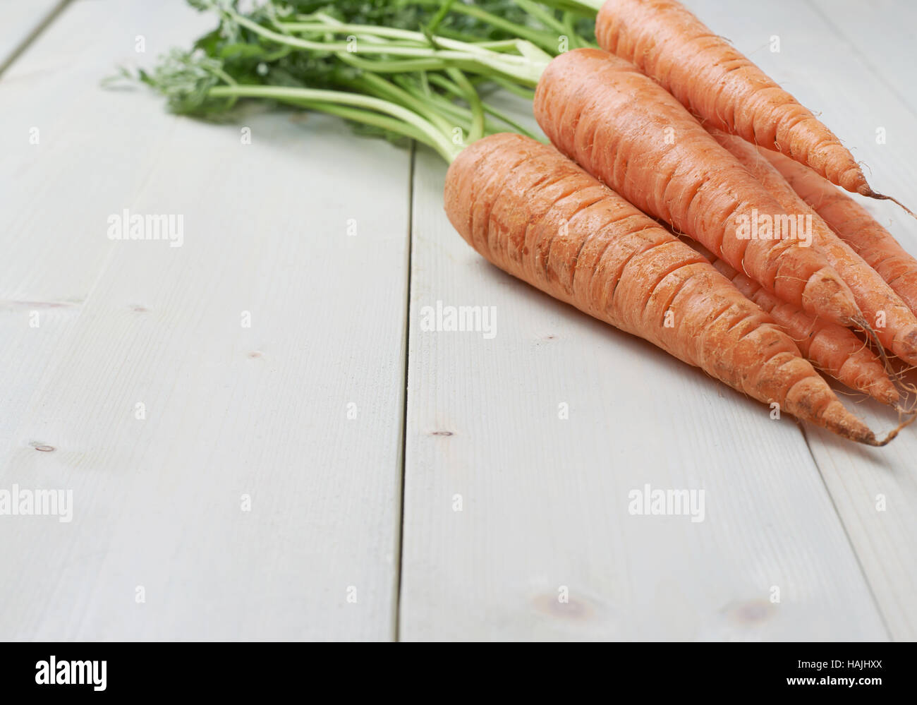 Raw whole carrot on wooden surface table Stock Photo - Alamy