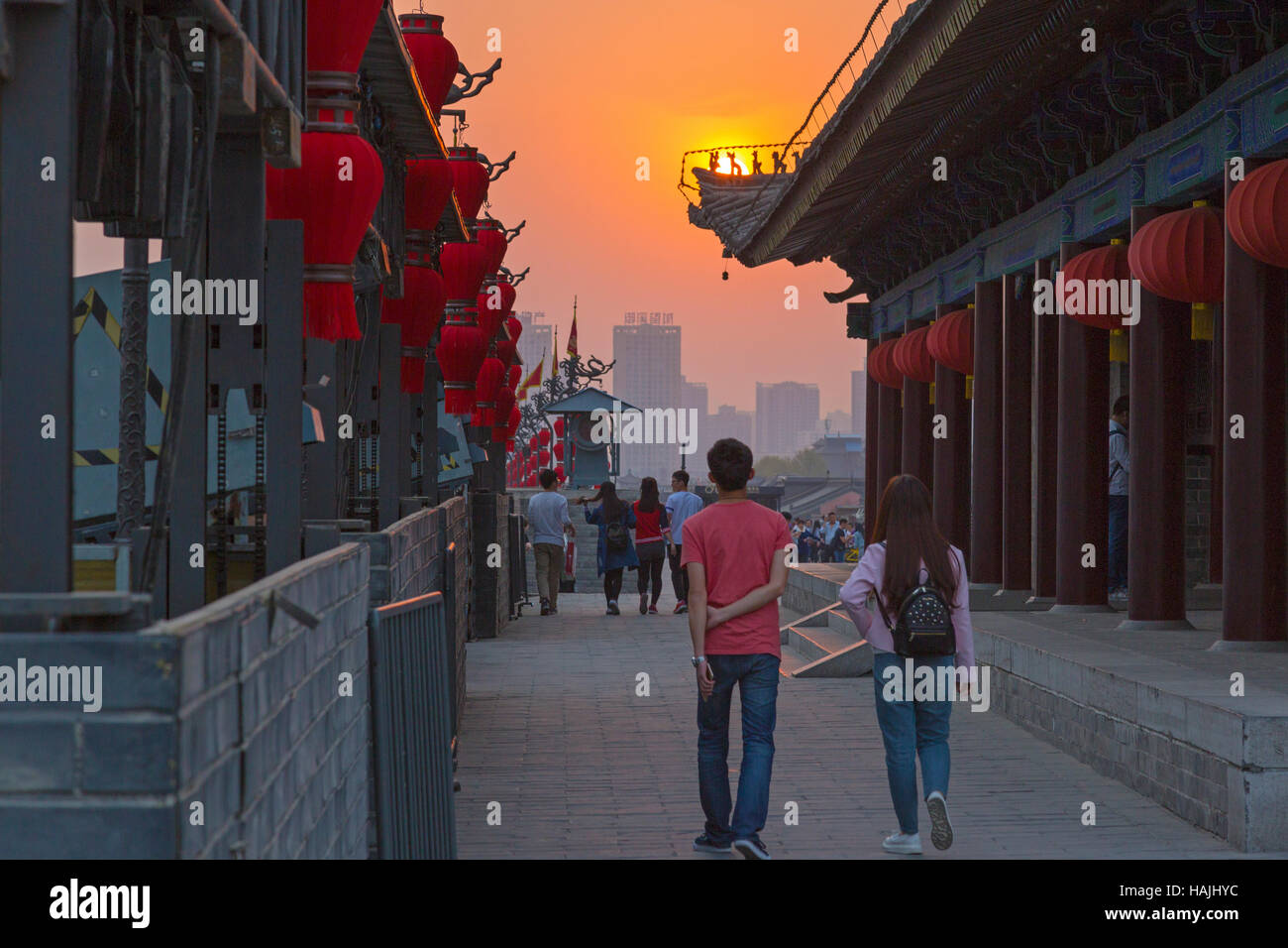 Tourists and buildings on Xian city walls at sunset, Shaanxi province ...