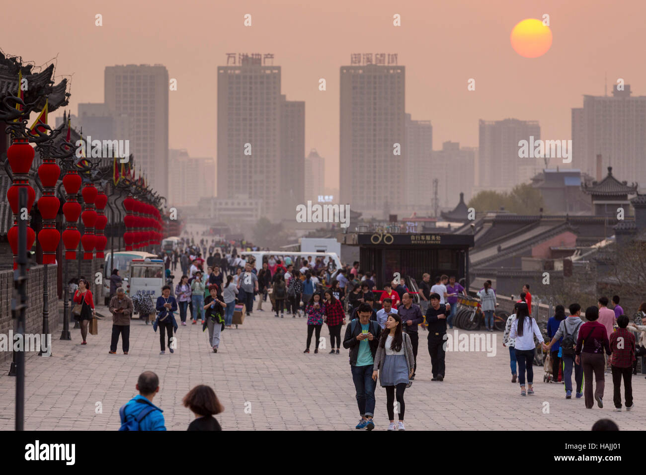 Tourists walking on Xian city walls at sunset, Shaanxi province, China ...