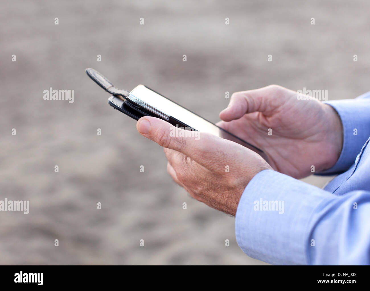 A businessman sends a message with a mobile phone Stock Photo - Alamy
