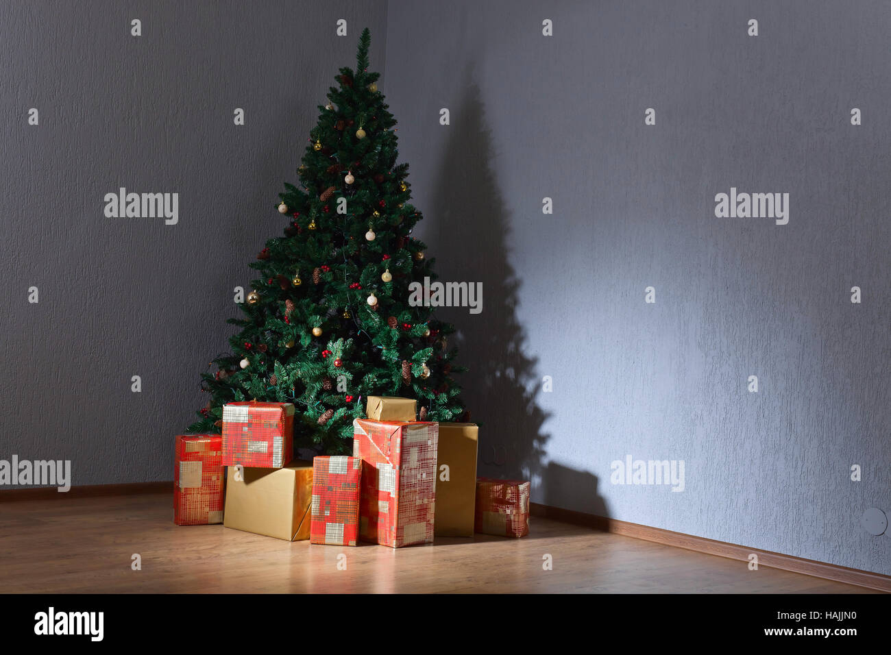 Christmas tree with gifts in an empty room Stock Photo - Alamy