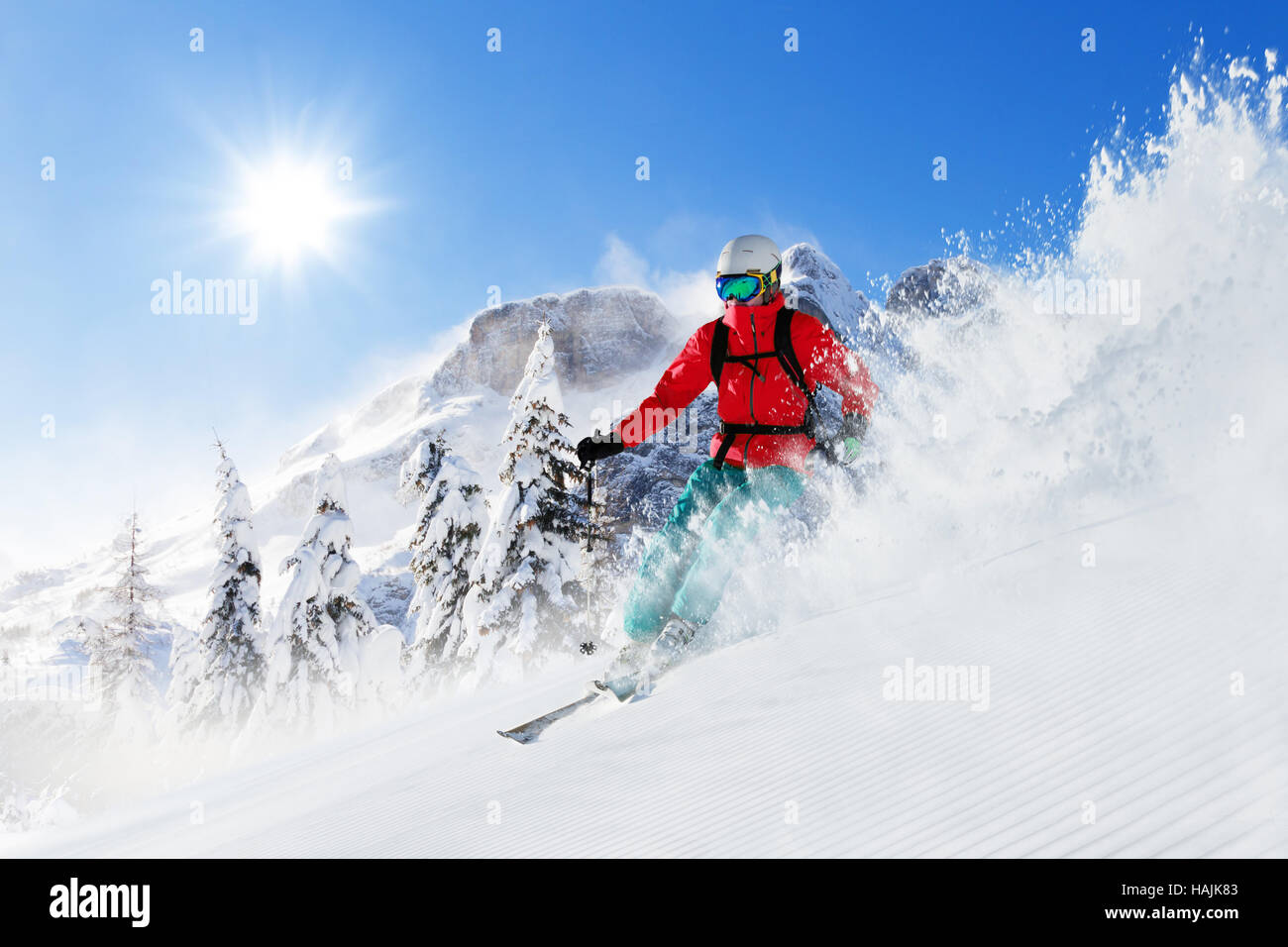 Freeride skier with rucksack running downhill in freeze motion of snow ...