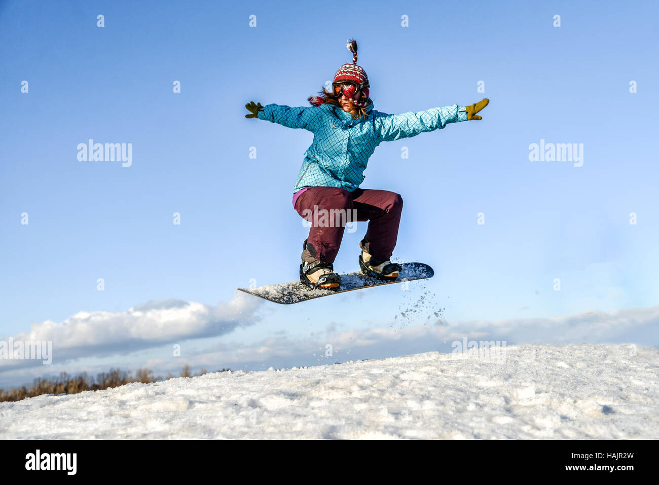 Young woman on the snowboard jumping Stock Photo - Alamy