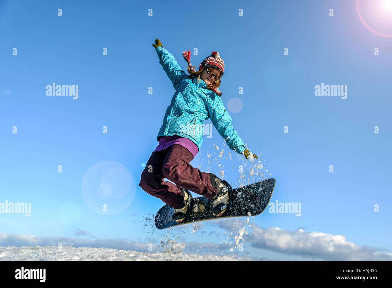 Young woman on the snowboard jumping Stock Photo - Alamy