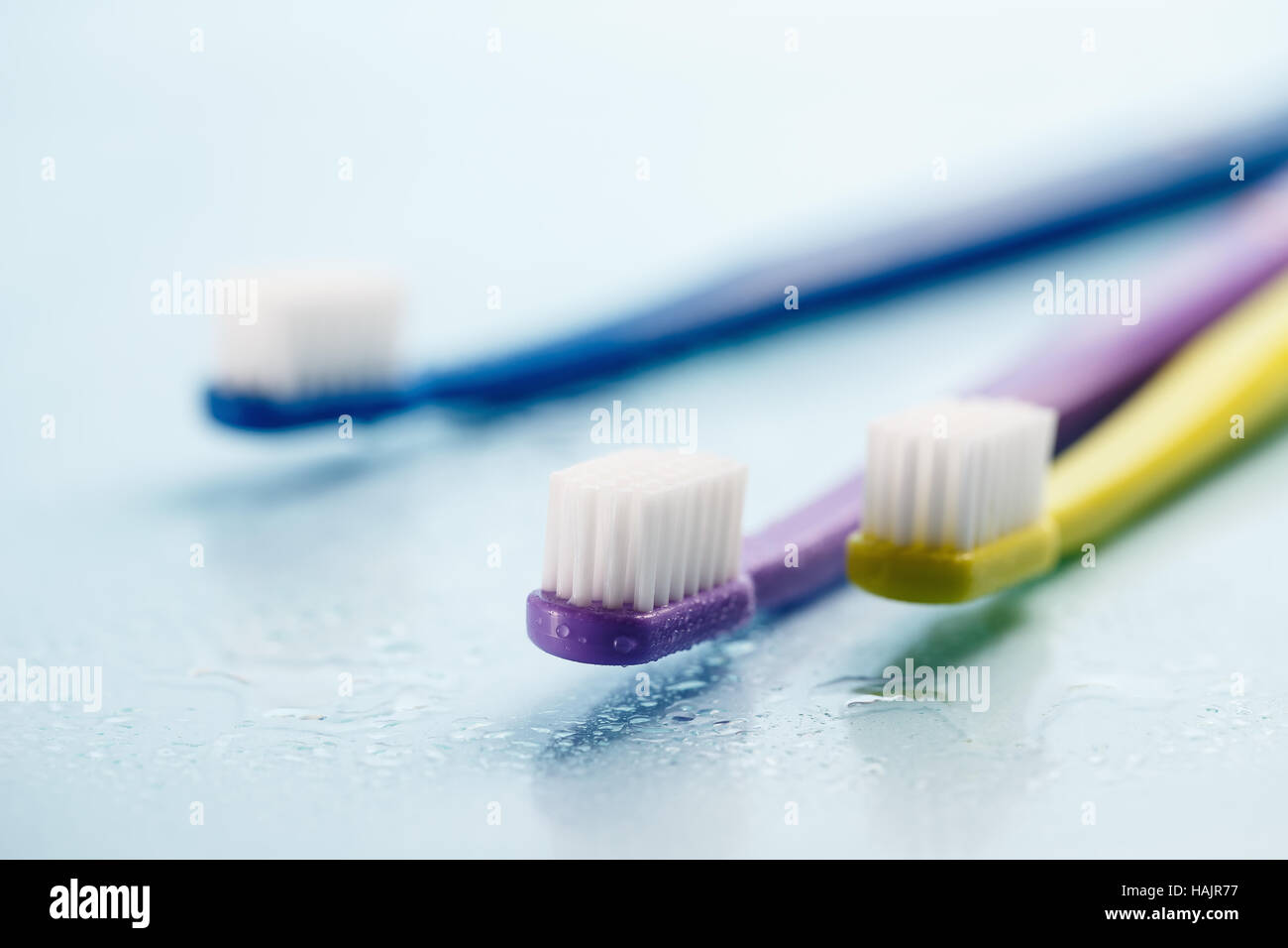 Toothbrushes on wet surface Stock Photo - Alamy