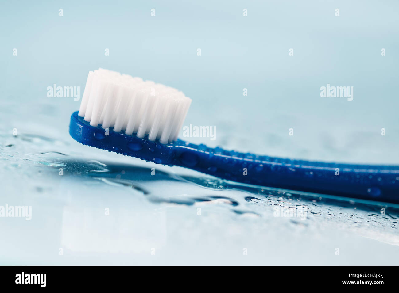 Blue toothbrush on wet surface Stock Photo - Alamy