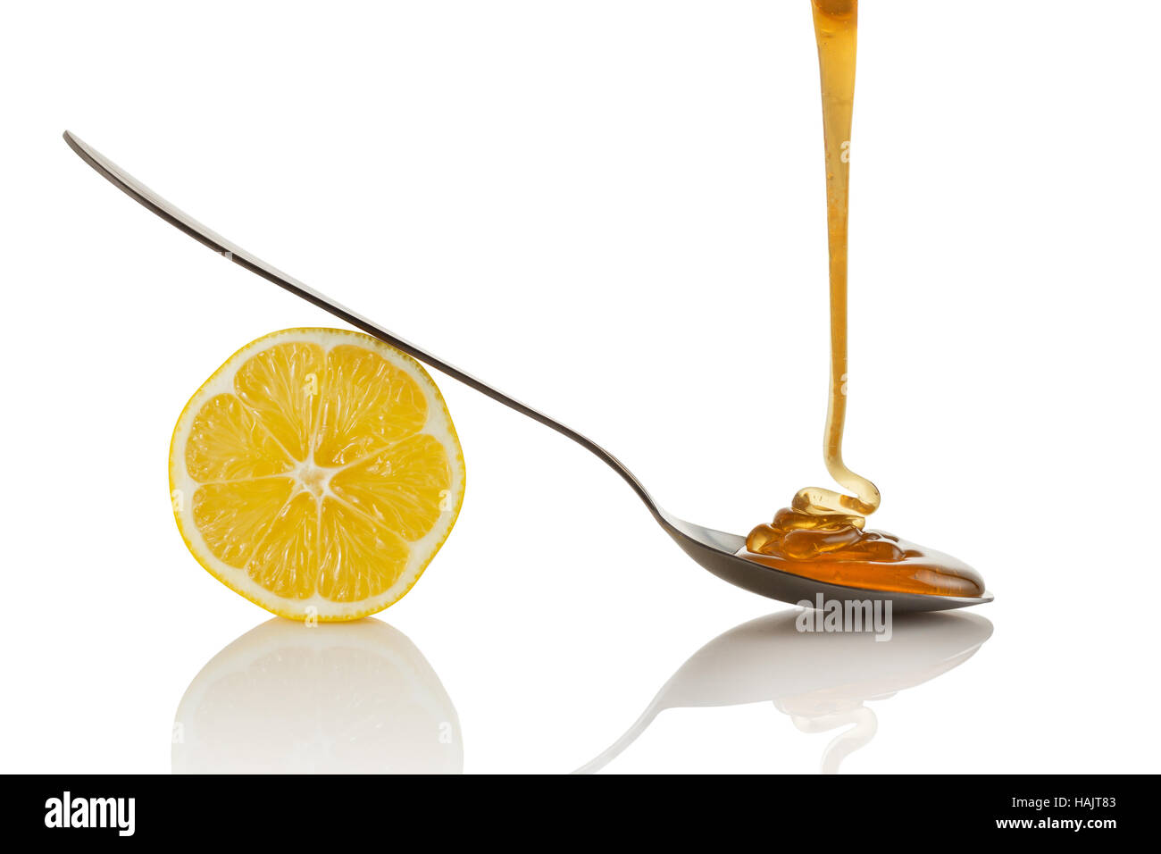 Lemon slice and honey flowing on spoon Stock Photo - Alamy