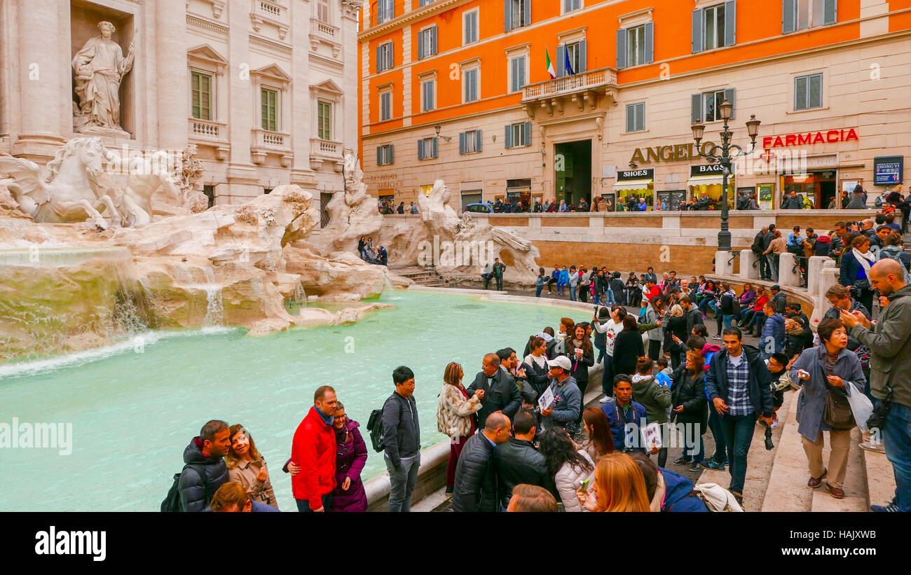 Crowd of tourists visiting the Fountains of Trevi in the historic ...