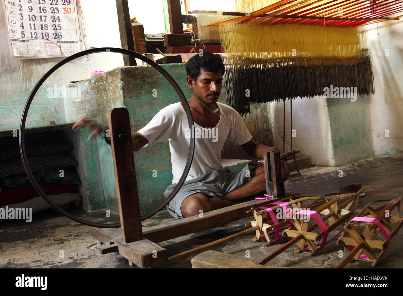 Kanchipuram Sari weaver using a spinning wheel to get yarn ready for ...