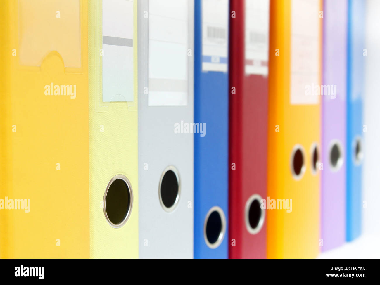 row of colorful ring binders on shelf Stock Photo - Alamy