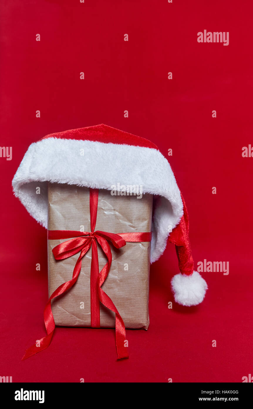 Box gift with Santa Claus hut on red background Stock Photo - Alamy