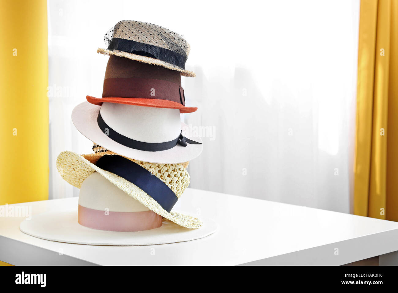 hat stack on white table in the room with copy space Stock Photo - Alamy