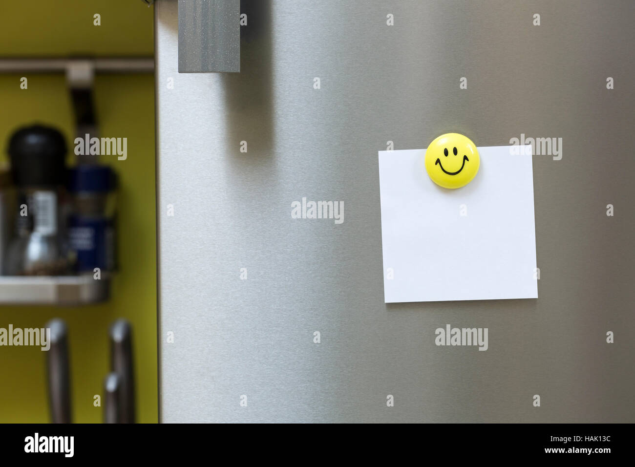 blank paper note with magnet hanging on fridge door Stock Photo - Alamy