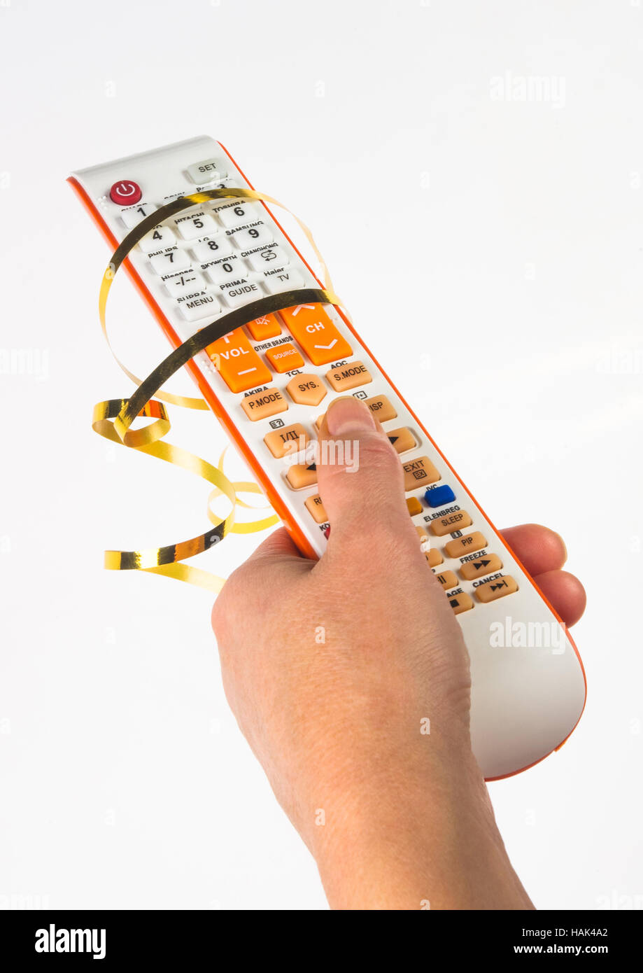 hand holding a remote control in a festive gold ribbon on white ...