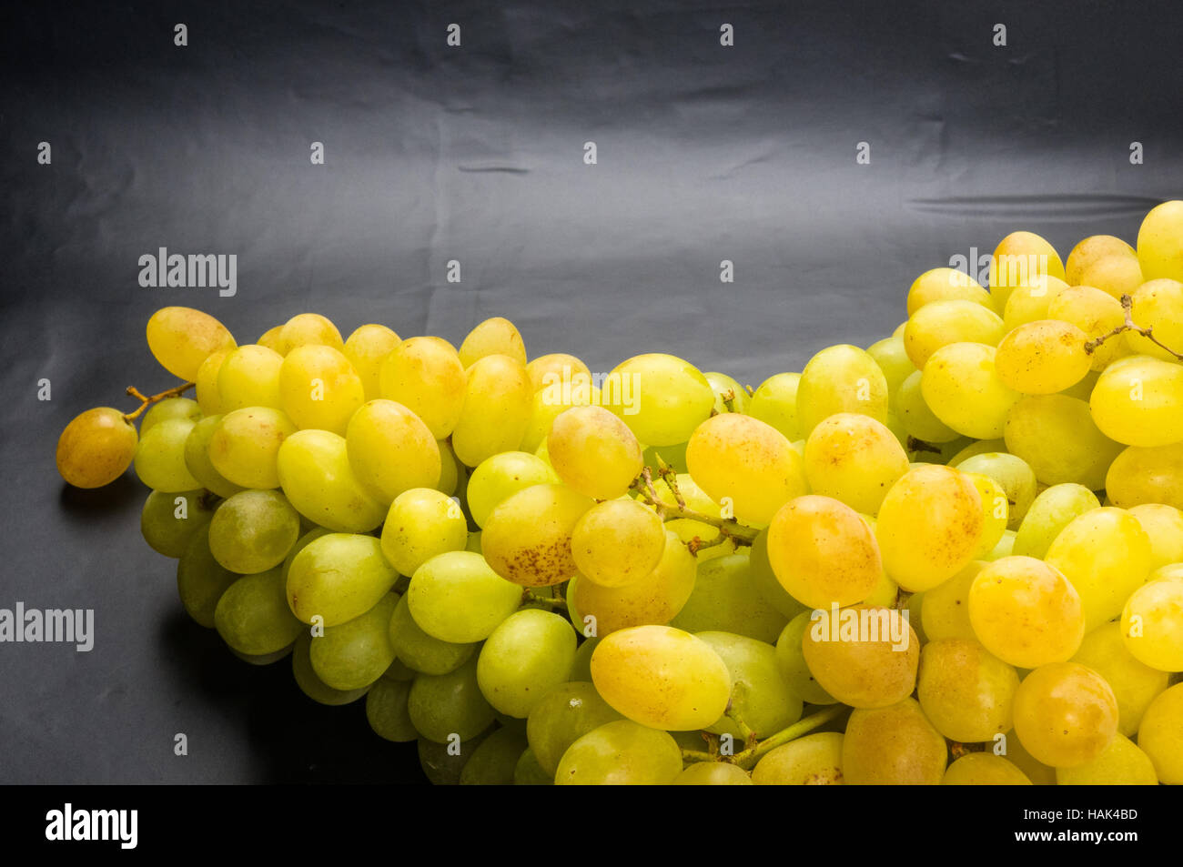 Large grapes cluster amber color on black background Stock Photo - Alamy