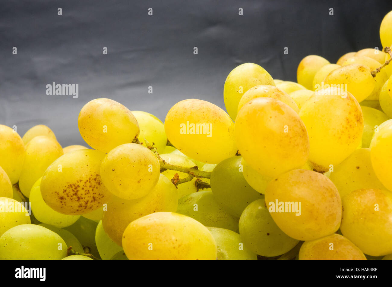 Large grapes cluster amber color on black background Stock Photo - Alamy