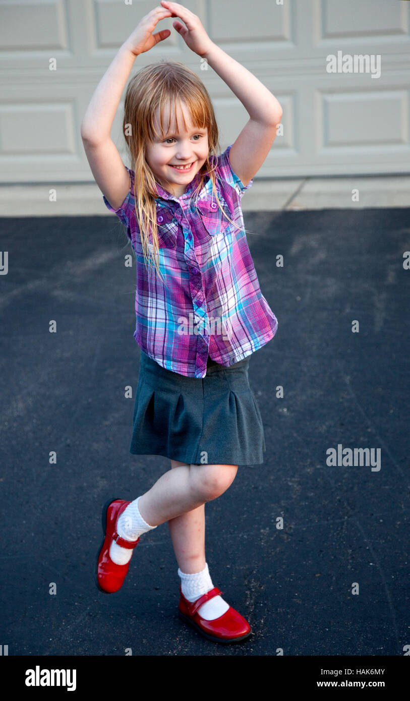 Young girl practicing a pirouette dance step on her driveway tarmac ...