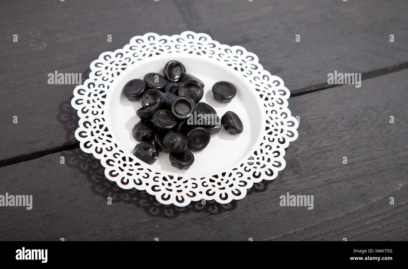 Traditional Dutch candy drop on little plate on wooden background Stock ...