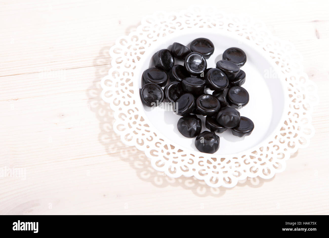 Traditional Dutch candy drop on little plate on wooden background Stock ...
