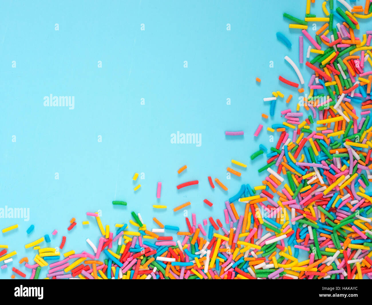 Border frame of colorful sprinkles on blue background with copyspace ...