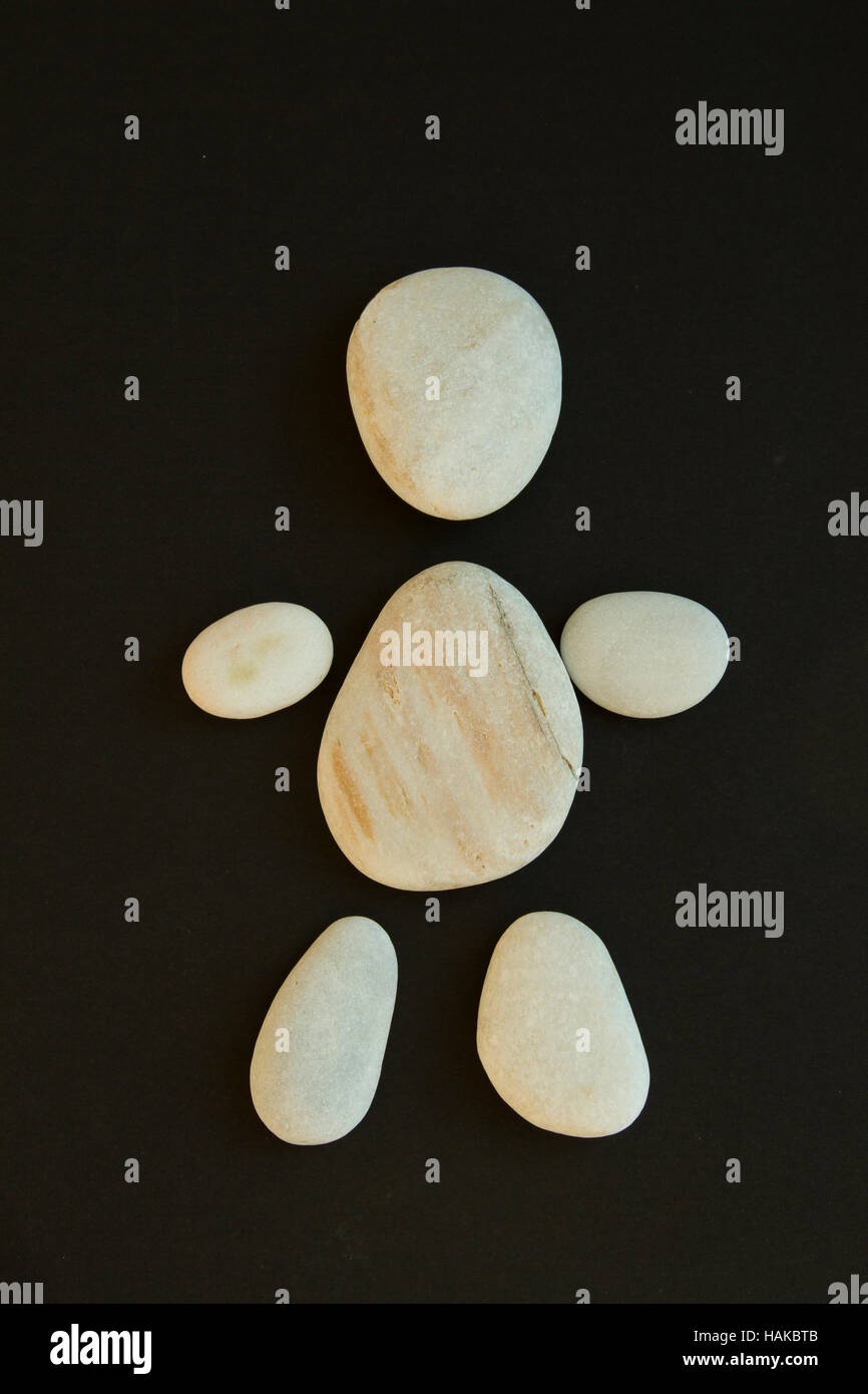 man from pebble stones on black background Stock Photo - Alamy