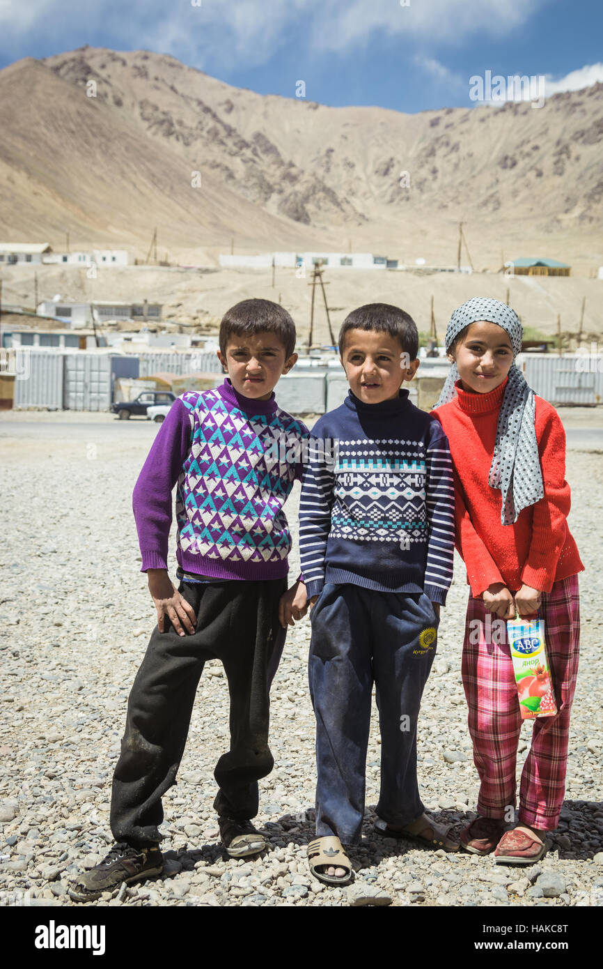 Young children, two boys and girl posing in the town center of Murghab ...