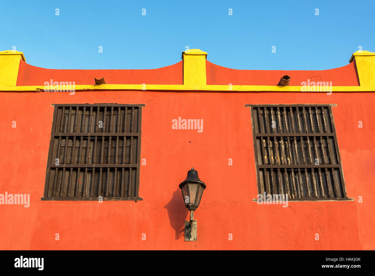 Two windows and a street light on a red colonial building in the ...