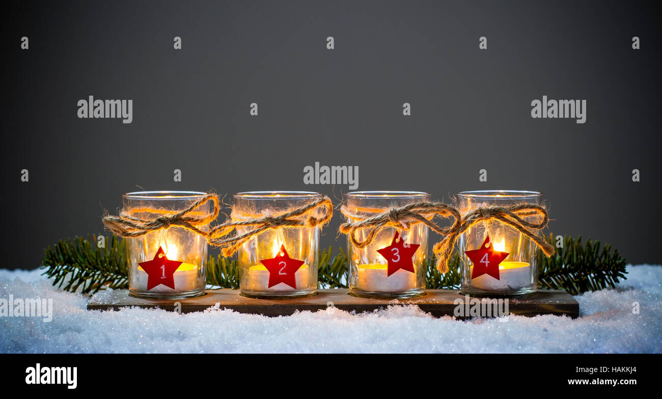 Four Advent candles in the snow, fourth Advent Stock Photo - Alamy