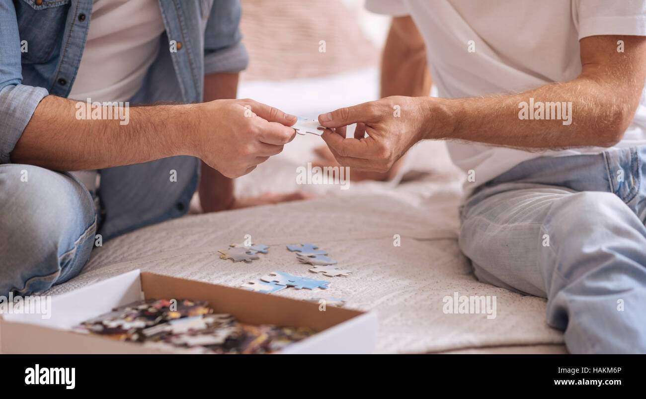 Colorful puzzle pieces in hands of two men Stock Photo - Alamy