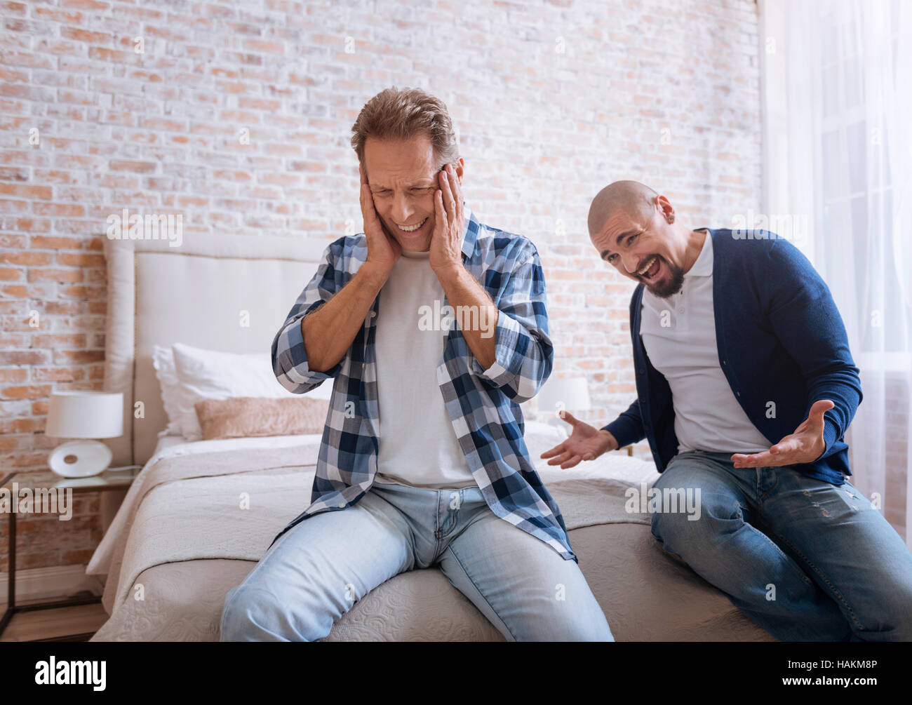 Choleric man screaming loudly on another person at home Stock Photo - Alamy