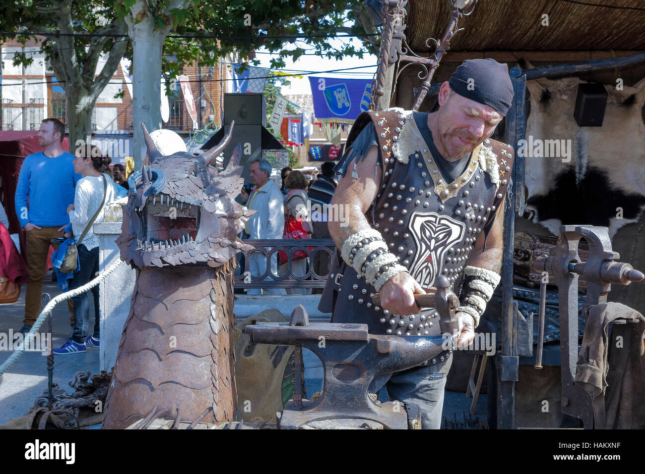 Blacksmith working outdoors during recreation of a medieval market ...
