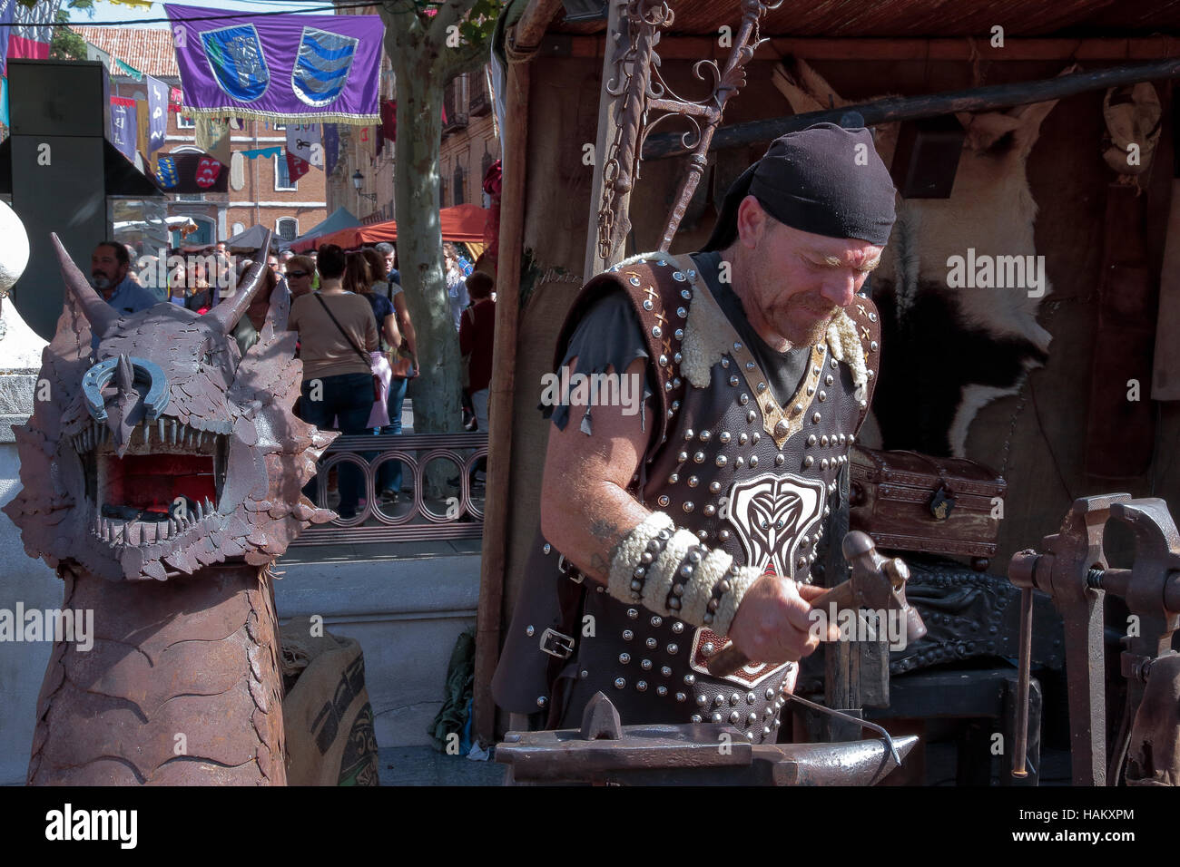 Blacksmith working outdoors during recreation of a medieval market ...