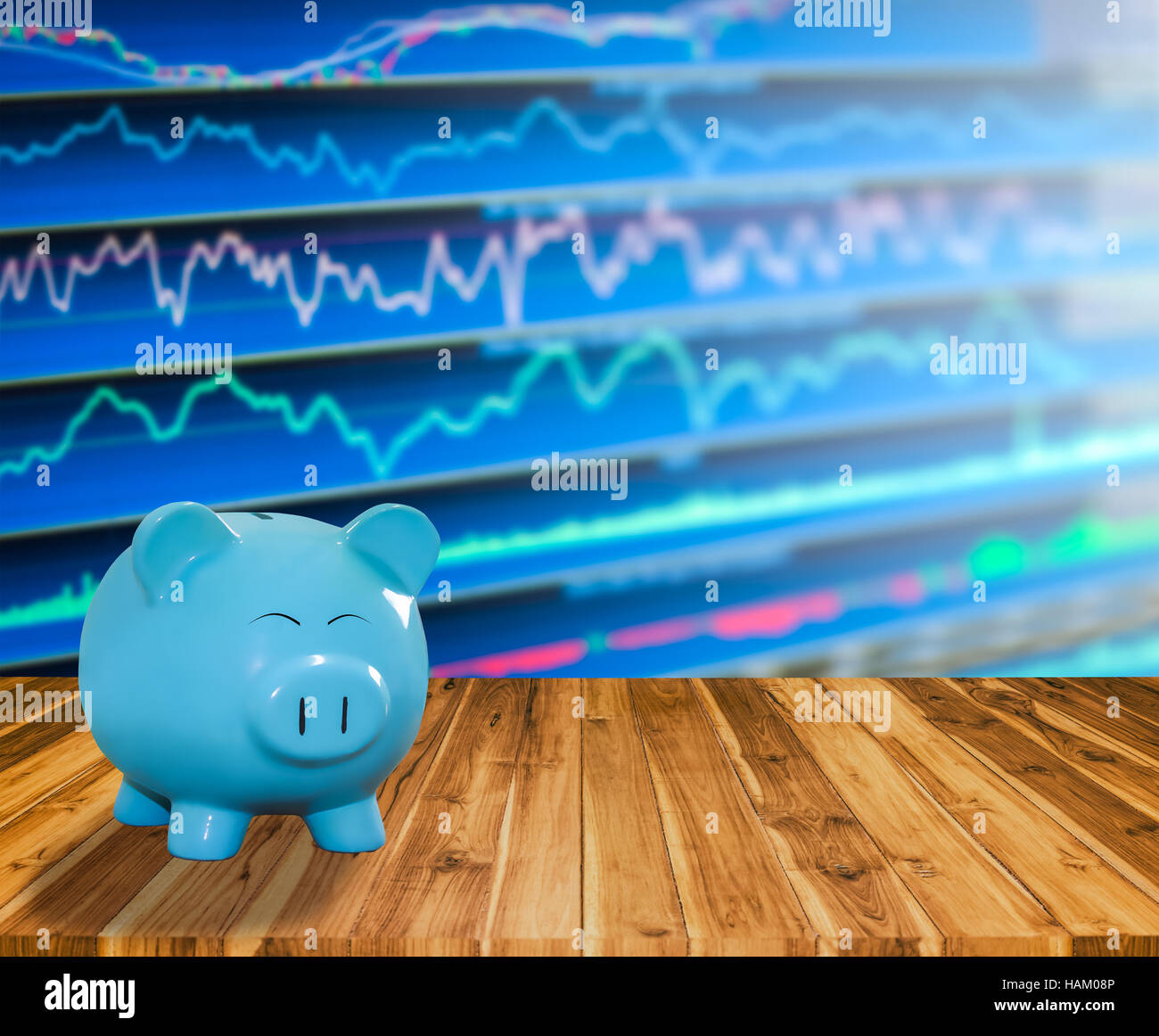 blue pig bank on wood background with blur stock market background ...