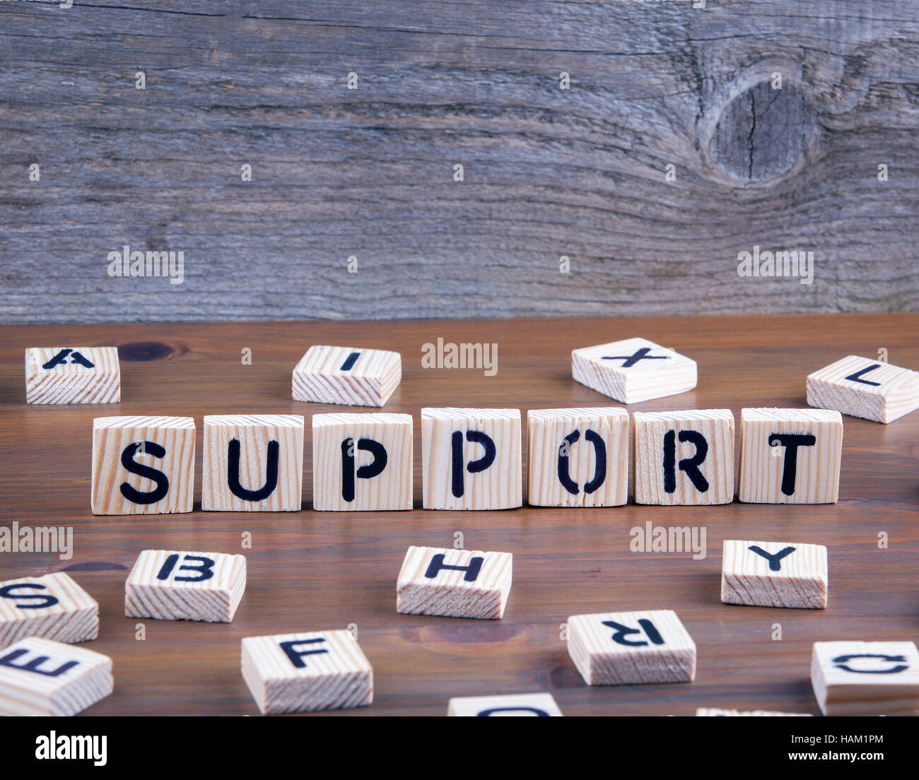 Support from wooden letters on wooden background Stock Photo - Alamy