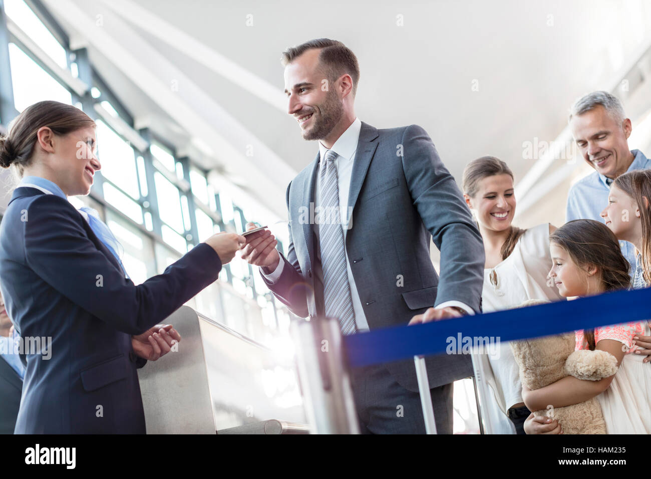 Flight attendant checking tickets in airport Stock Photo - Alamy