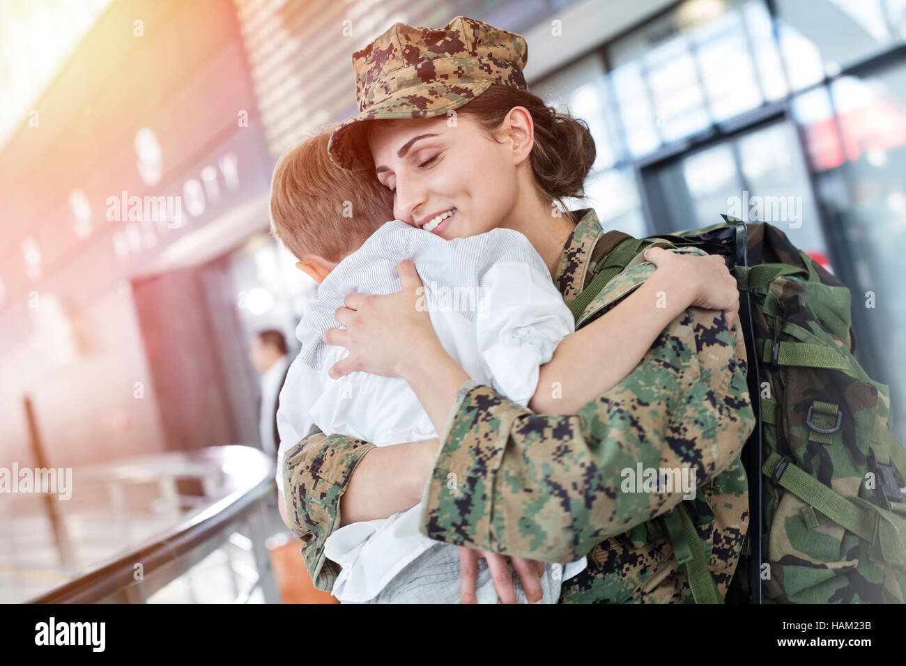 Son greeting and hugging soldier mom at airport Stock Photo - Alamy